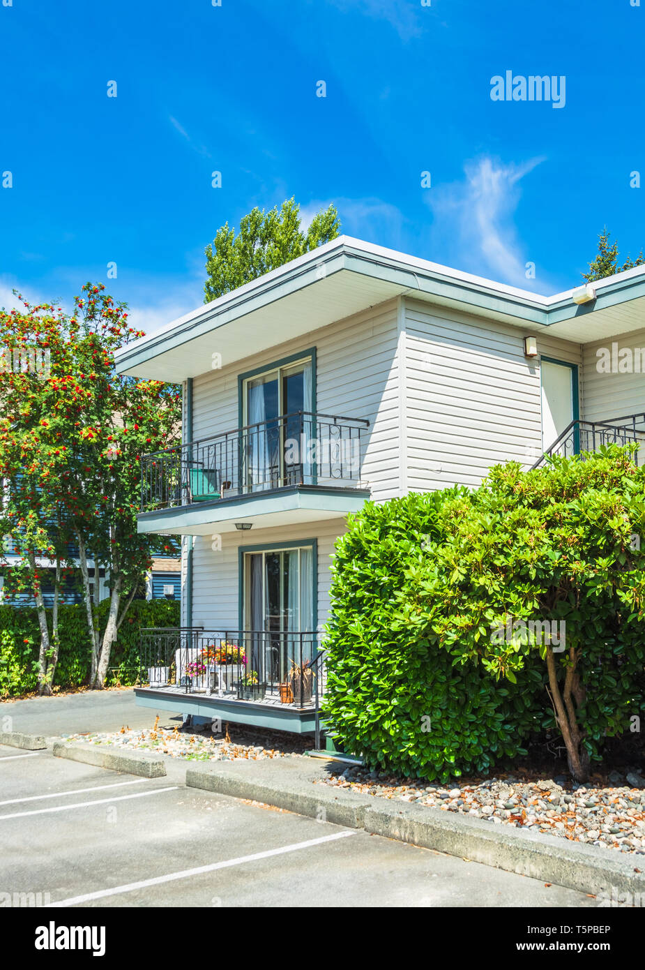 Front side of apartment building with small balconies and parking in ...