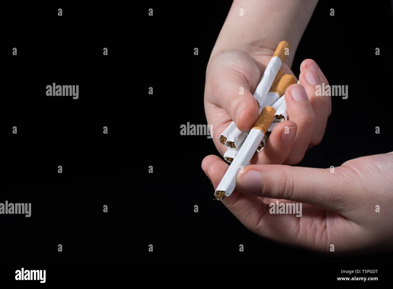 Hand is giving out cigarettes on a black background Stock Photo - Alamy