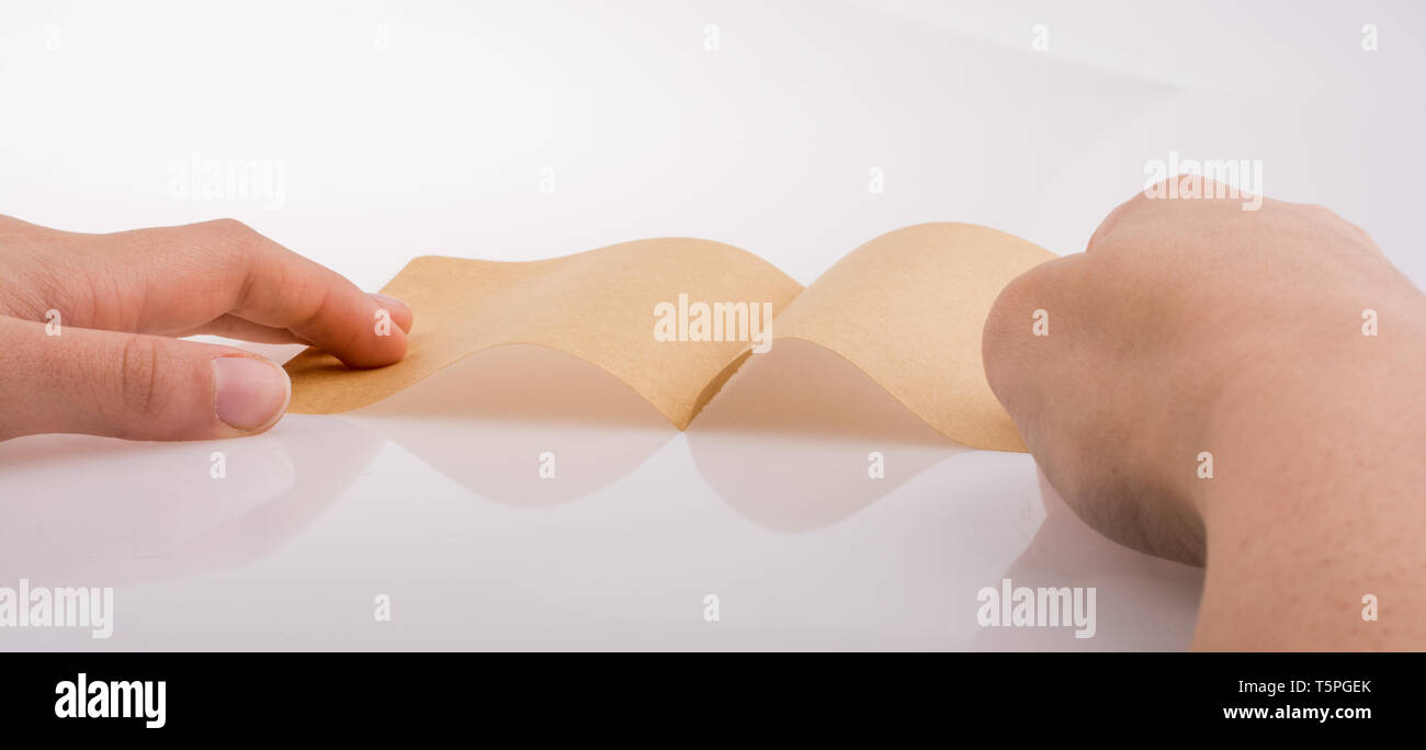 Hand holding a sheet of paper on a white background Stock Photo - Alamy