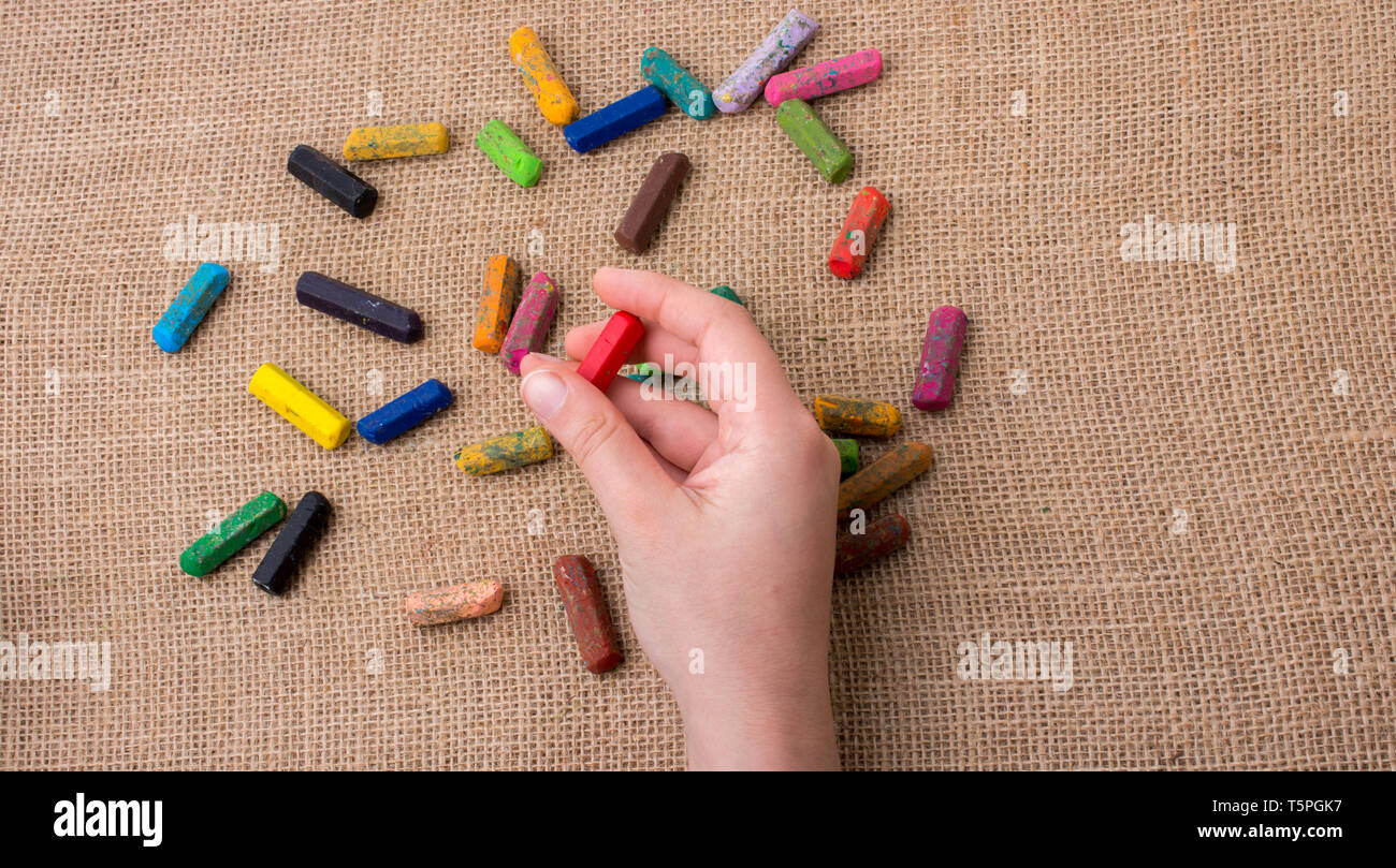 Used color crayons and a hand holding one Stock Photo - Alamy