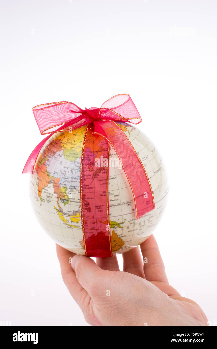 Globe tied with red ribbon on a white background Stock Photo - Alamy