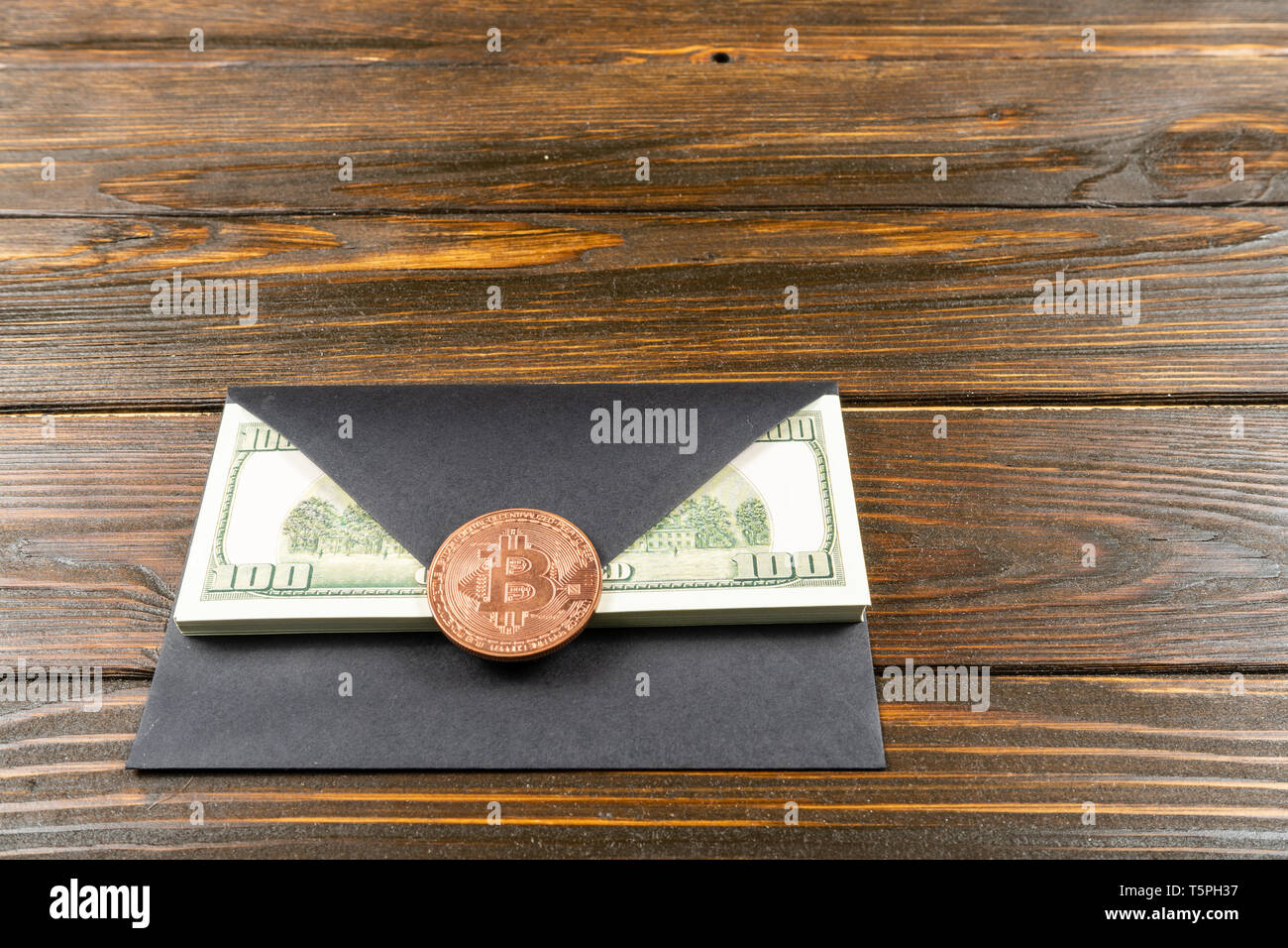 Prop Money Dollars in black envelope.Bitcoin as a seal.Brown wooden ...