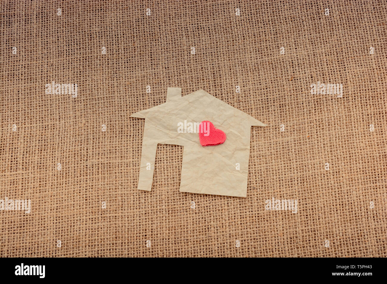 Heart shape on house shape cut out of paper with a canvas background ...
