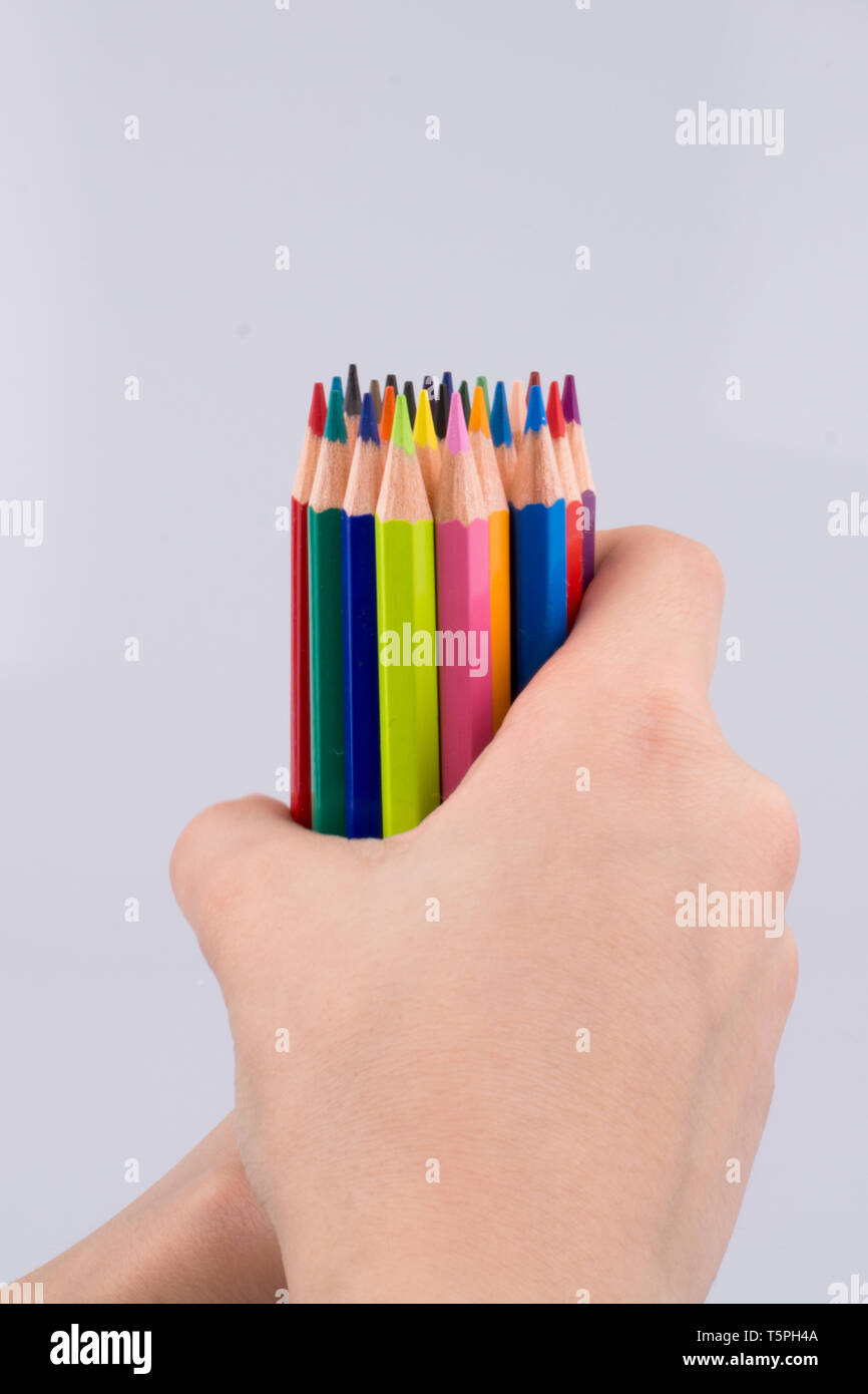 Hand holdin color pencils on a white background Stock Photo - Alamy