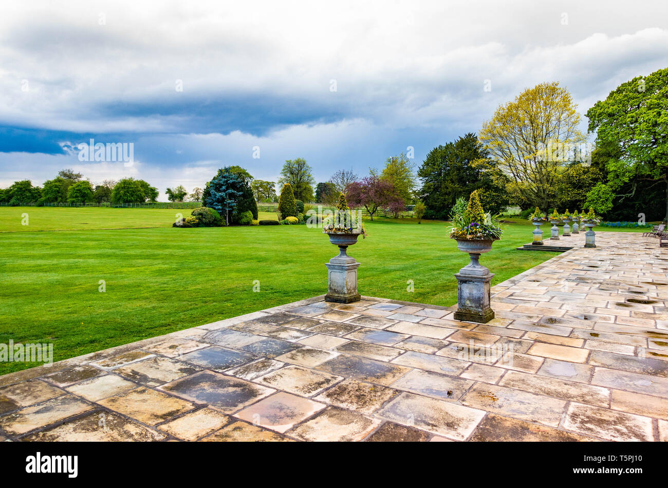 Wet patio stone slabs with storm clouds above in the April sky Stock ...