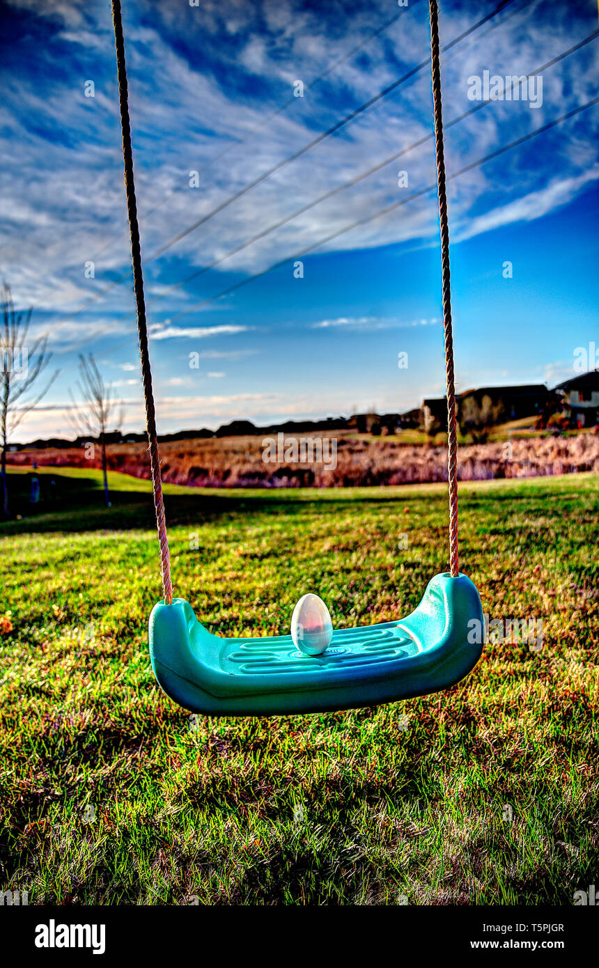 Easter Egg on swing with sky and grass background Stock Photo - Alamy