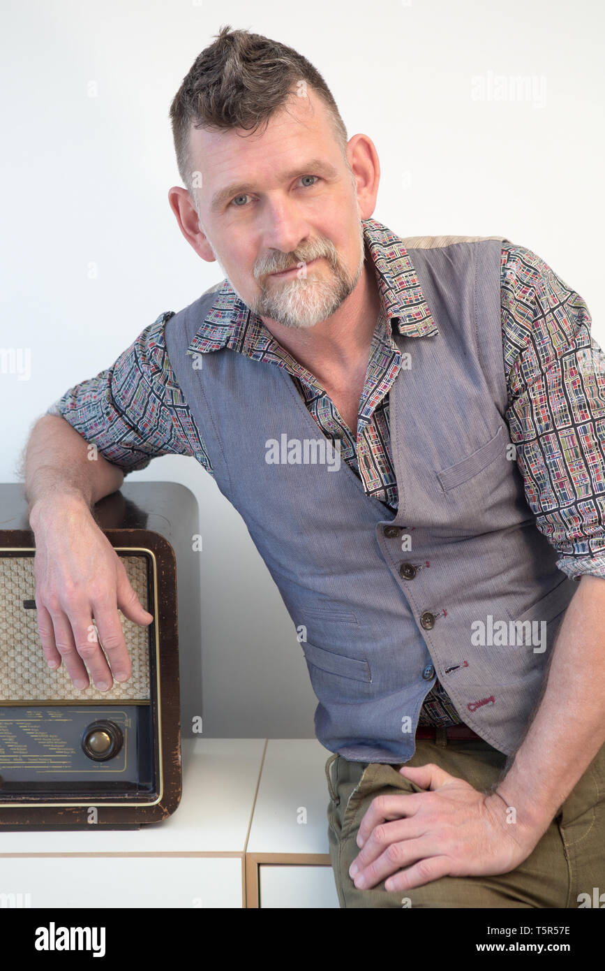 portrait of handsome man in his 50s next to vintage radio Stock Photo ...