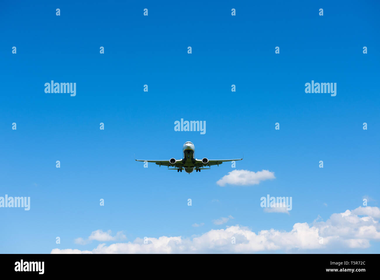 Airplane in blue sky front view from ground Stock Photo - Alamy