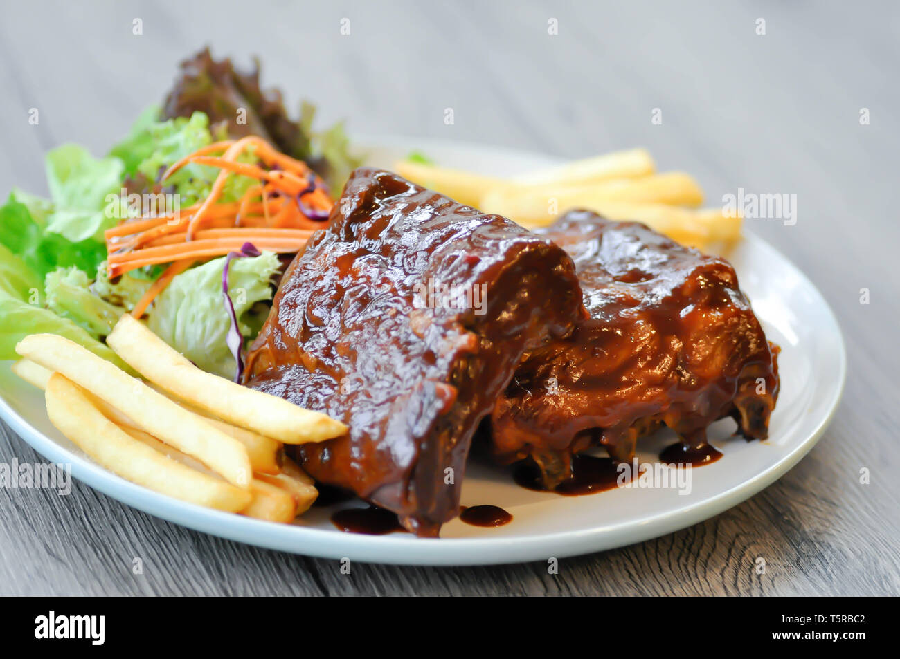 barbecue pork rib with french fries and vegetable Stock Photo - Alamy