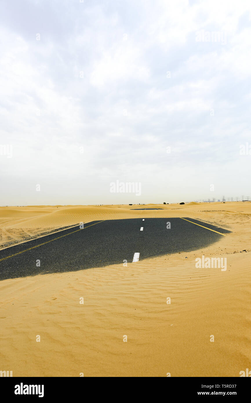 (Selective focus) Stunning view of a deserted road covered by sand ...