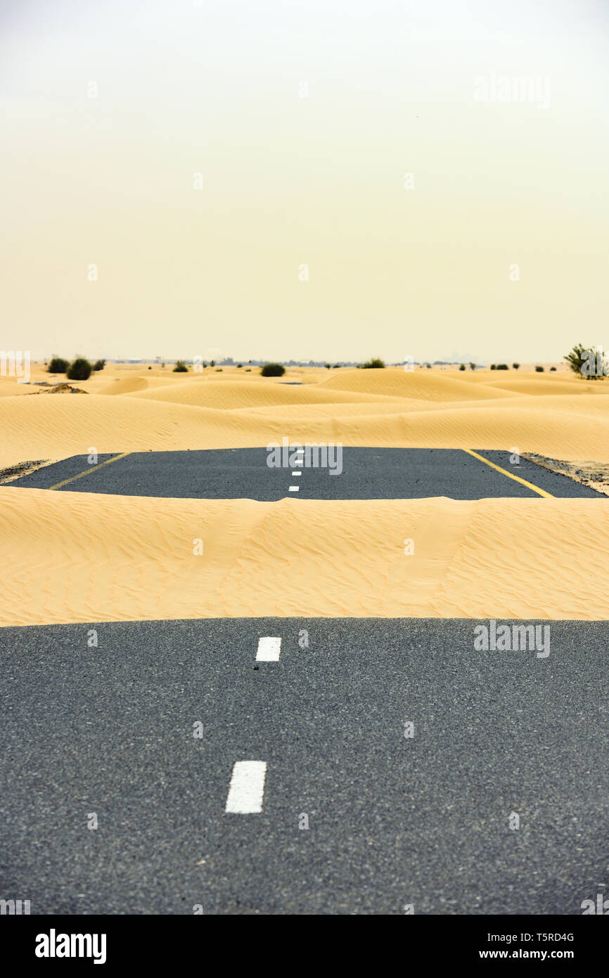 (Selective focus) Stunning view of a deserted road covered by sand ...