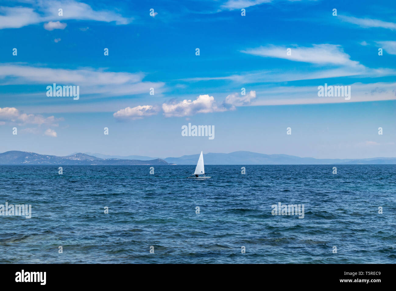 Sailing in Aegean sea, Greece. Small optimist boat with white sail ...