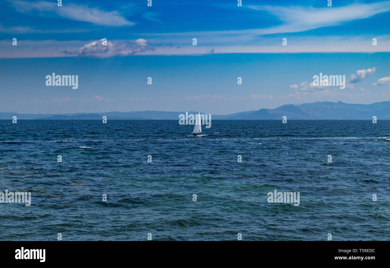 Sailing in Aegean sea, Greece. Small optimist boat with white sail ...