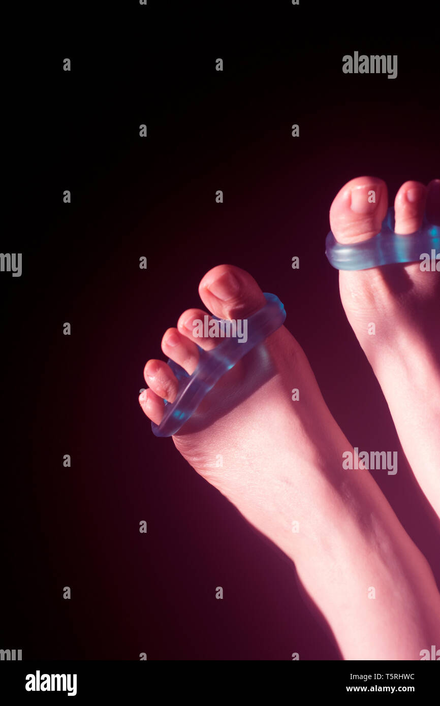 Young woman with silicone toe separator to separate toes to pedicure ...