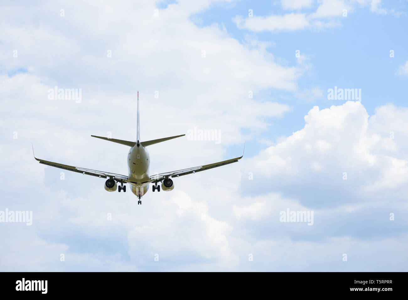 Passenger airplane in the clouds rear side view Stock Photo - Alamy