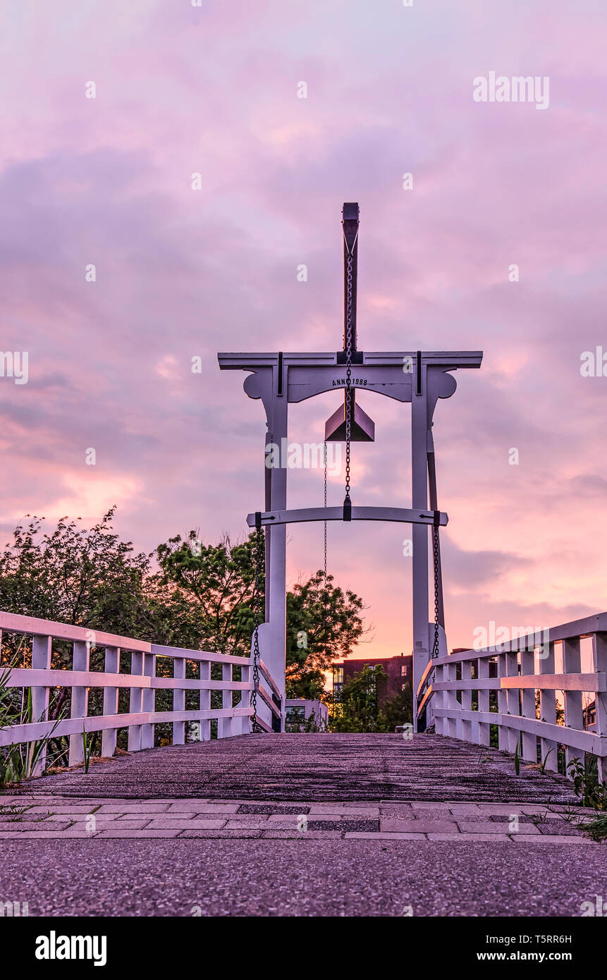 Traditional white wooden drawbridge across a Dutch canal with a ...