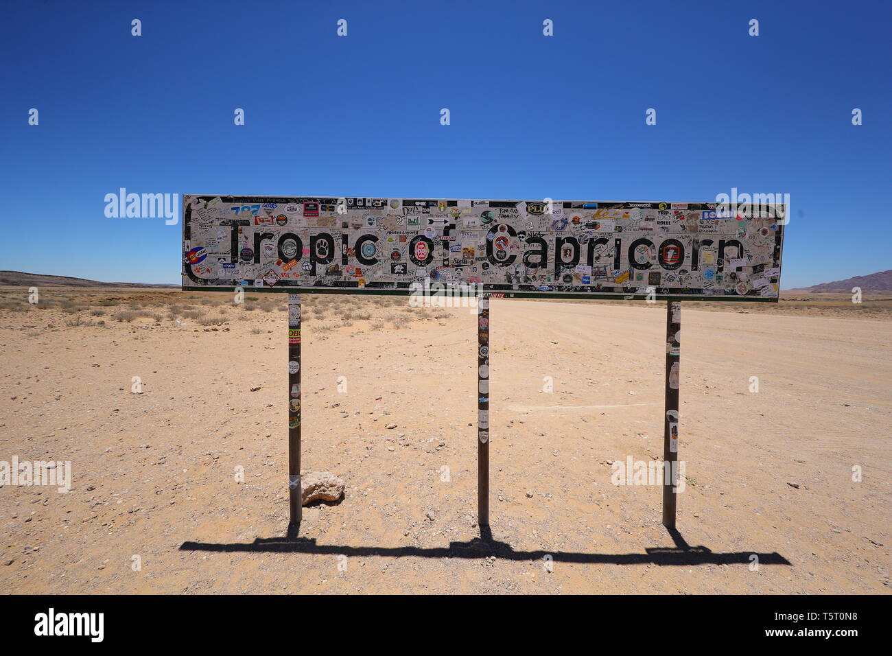 The Tropic of Capricorn latitude line and sign along a gravel road in ...