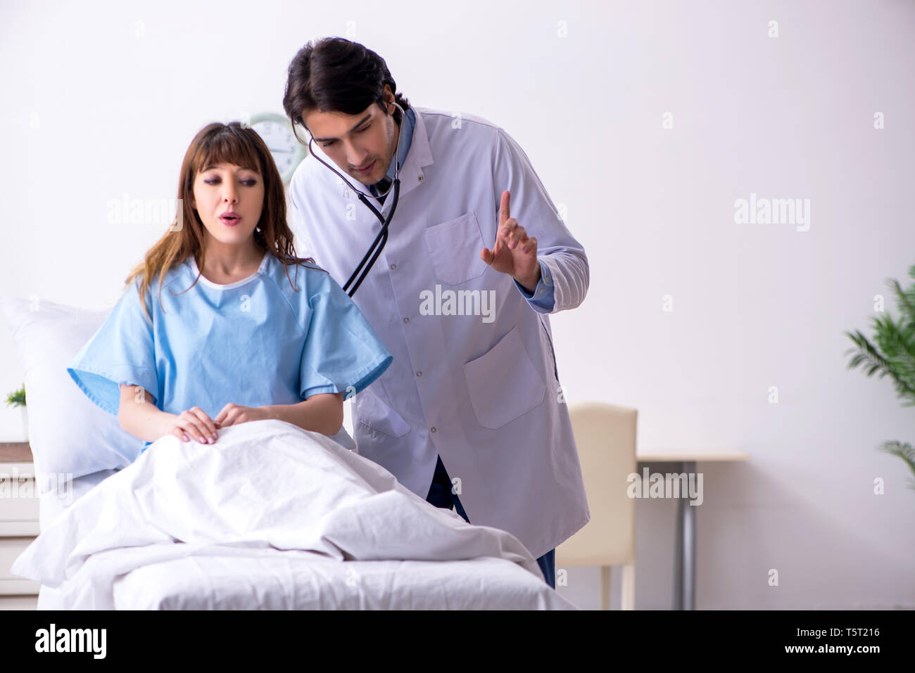 Male doctor visiting female patient in ward Stock Photo - Alamy