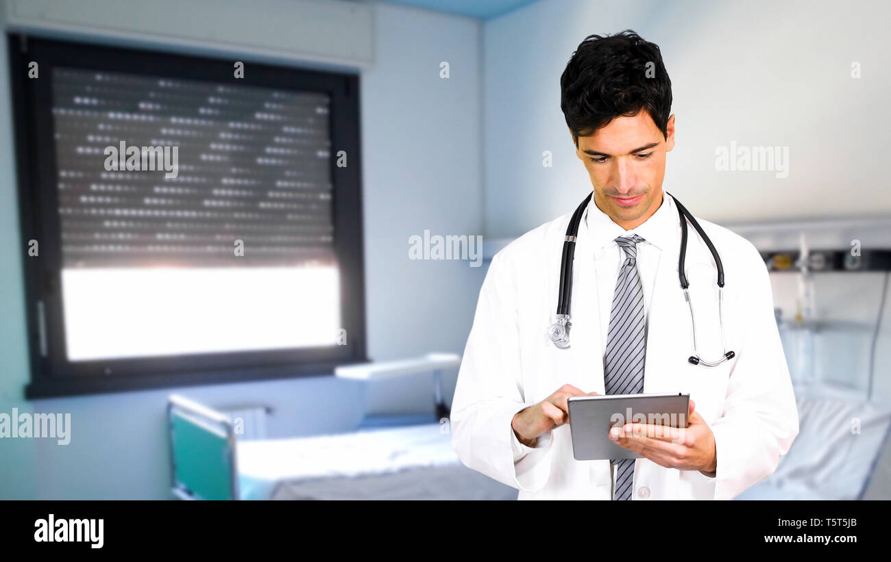 Serious doctor man browsing a tablet Stock Photo - Alamy