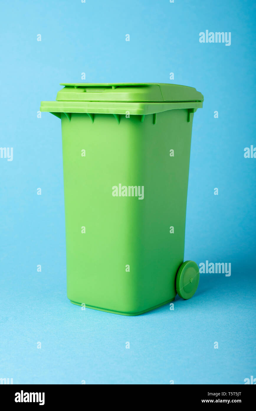 Green dustbin on a blue background. Recycling. Materials for recycling ...