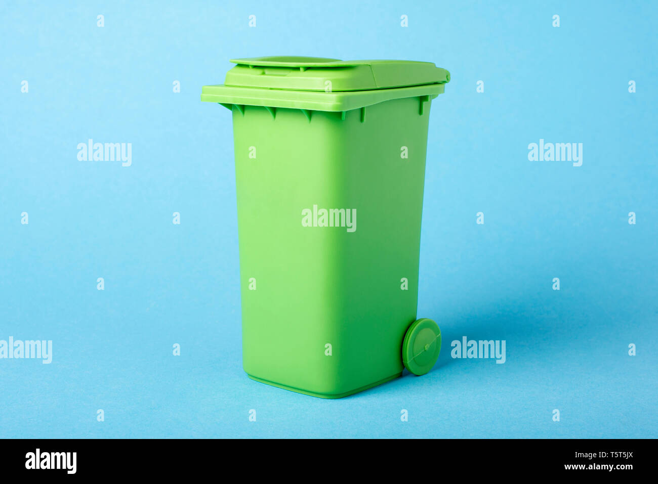 Green dustbin on a blue background. Recycling. Materials for recycling ...