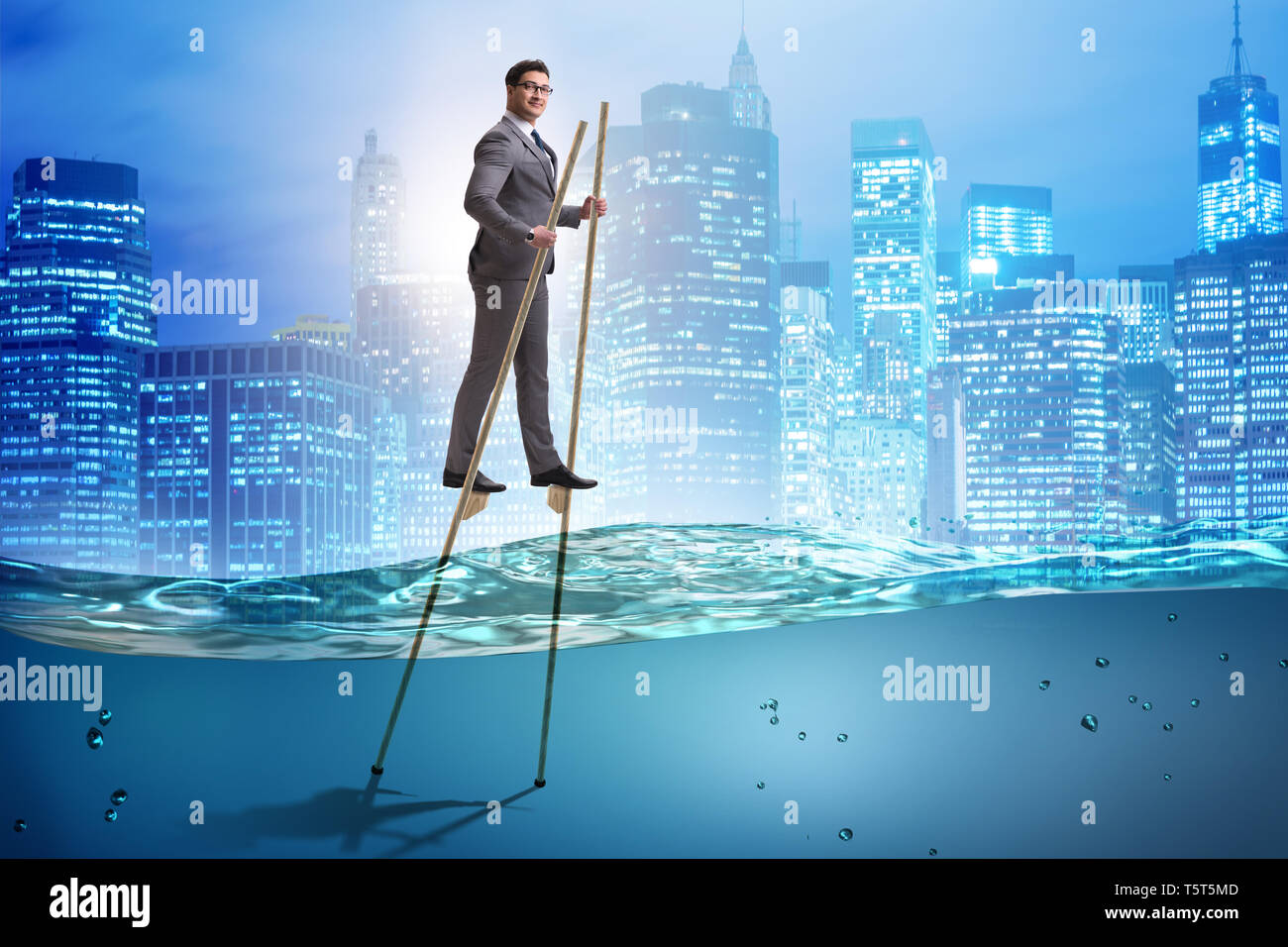 Businessman walking on stilts in water sea Stock Photo - Alamy