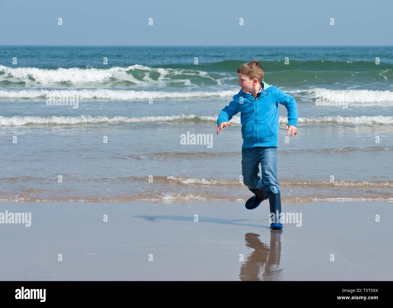 Young boy running on beach hi-res stock photography and images - Alamy