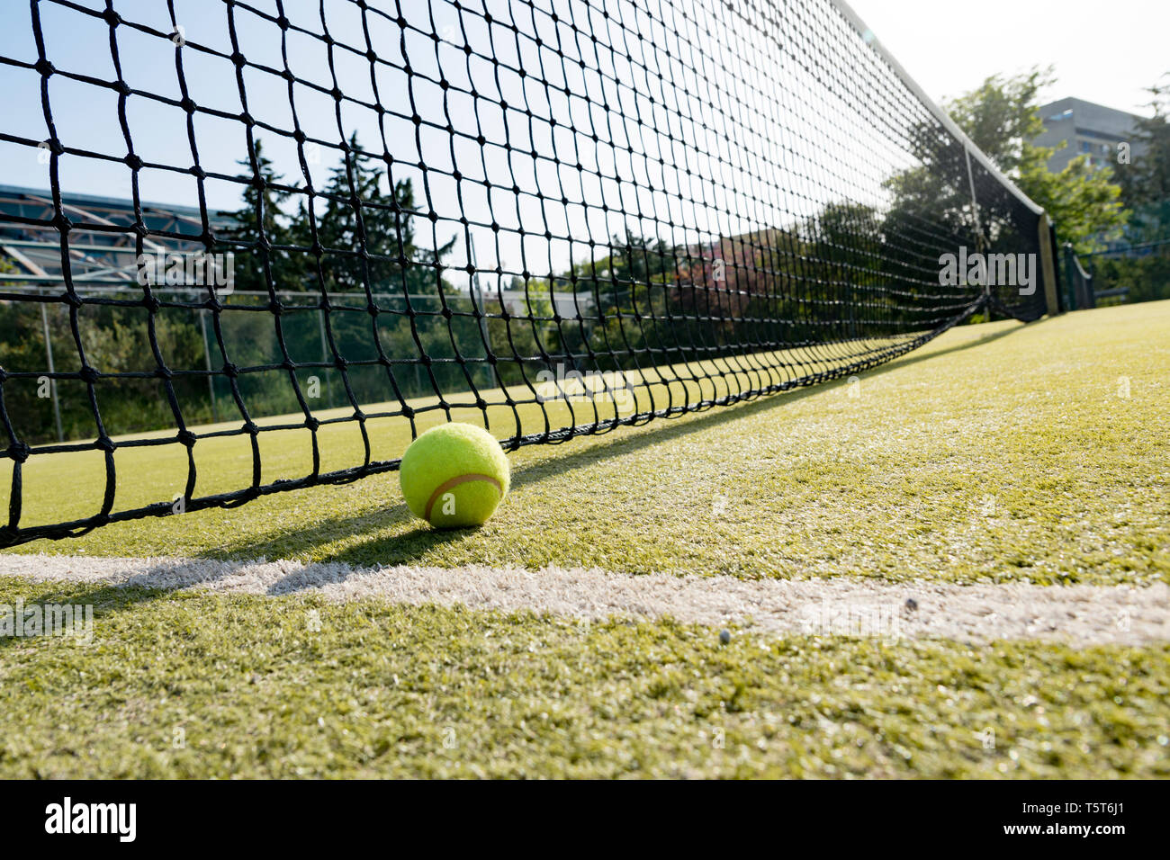 Tennis Ball on Court with Net Stock Photo - Alamy