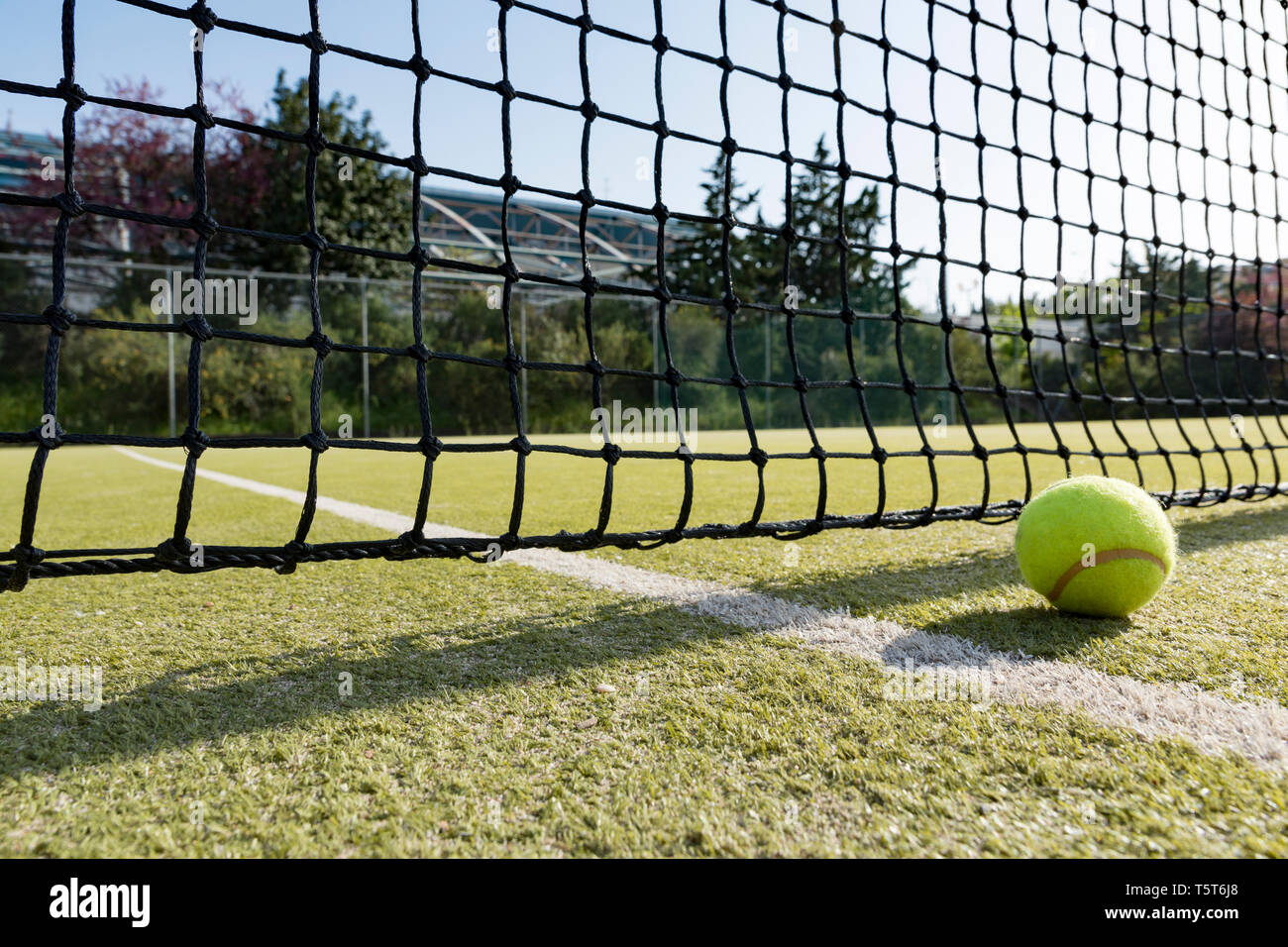 Tennis Ball on Court with Net Stock Photo - Alamy