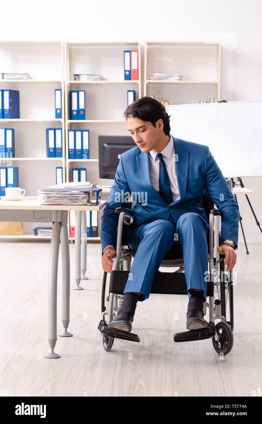 Male employee in wheelchair working at the office Stock Photo - Alamy