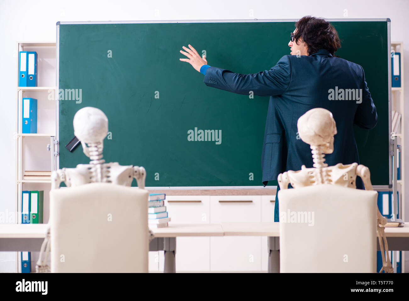 Male teacher and skeleton student in the classroom Stock Photo - Alamy
