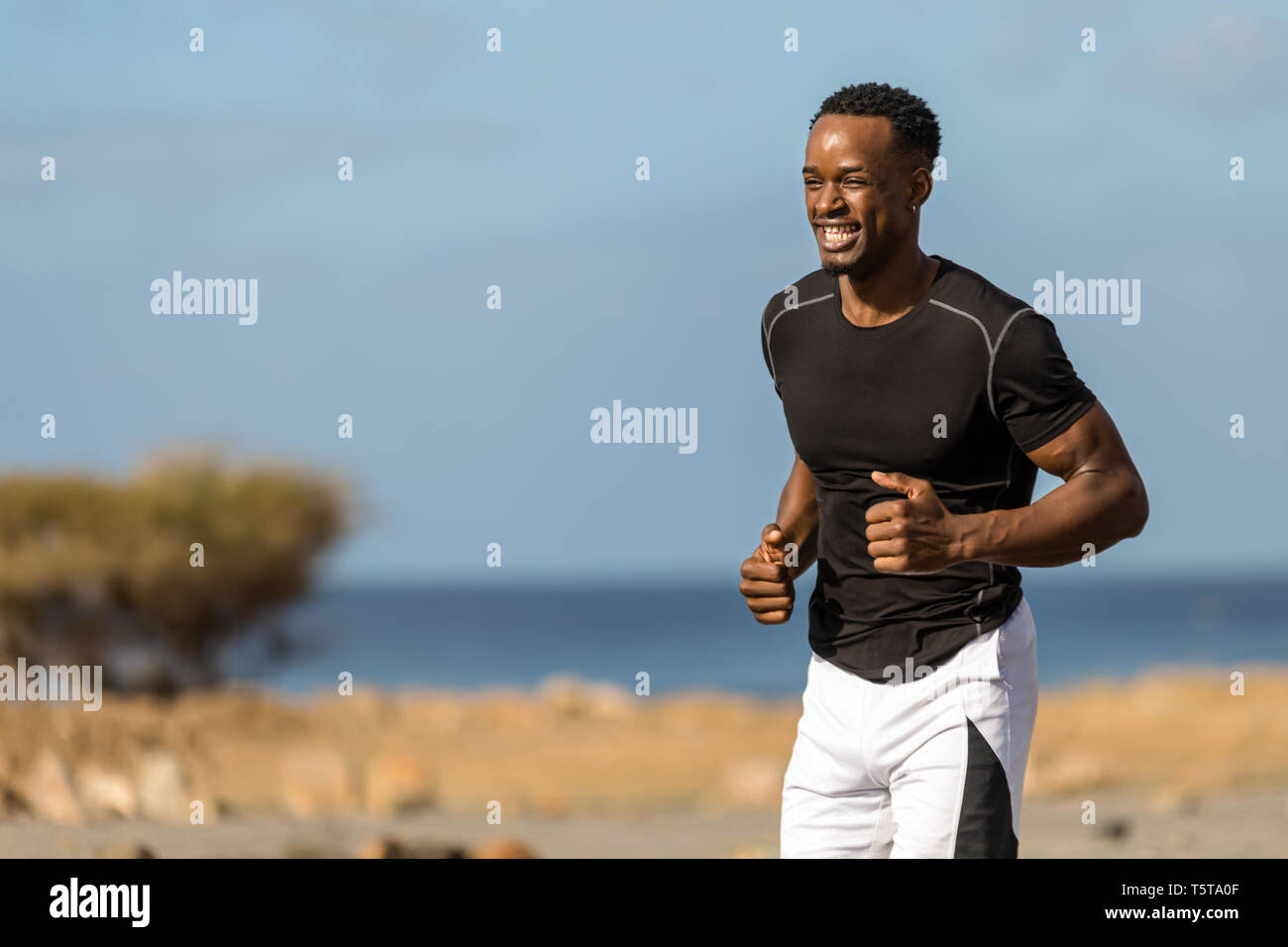 Black african american young man running outdoor Stock Photo - Alamy