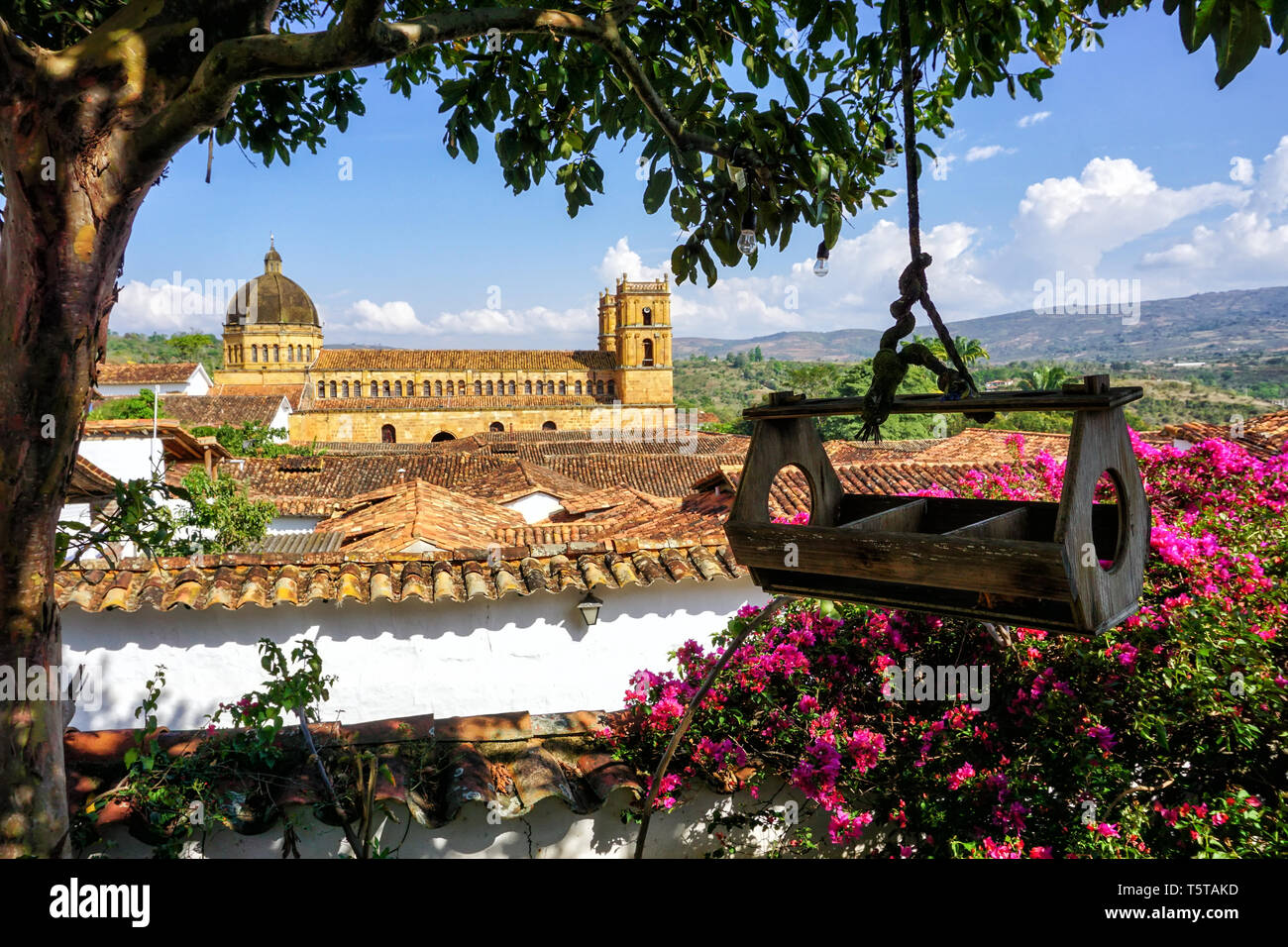 View of colorful garden, tree and church in Barichara, Colombia Stock ...