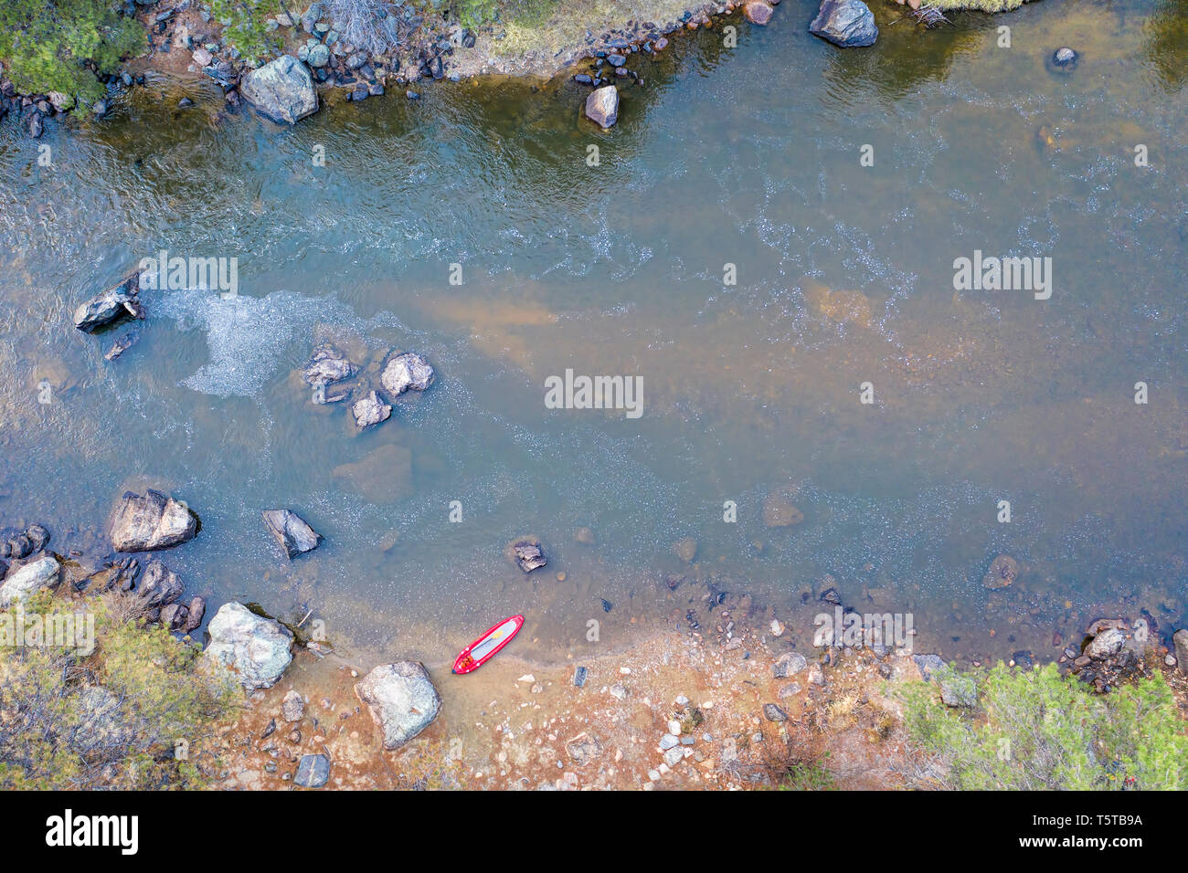 inflatable whitewater stand up paddleboard on a shore of mountain river ...