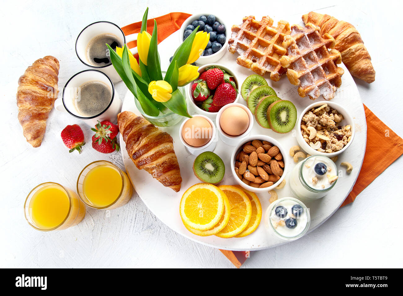 Breakfast table with eggs, berries, yogurt,waffle and croissant. Top ...