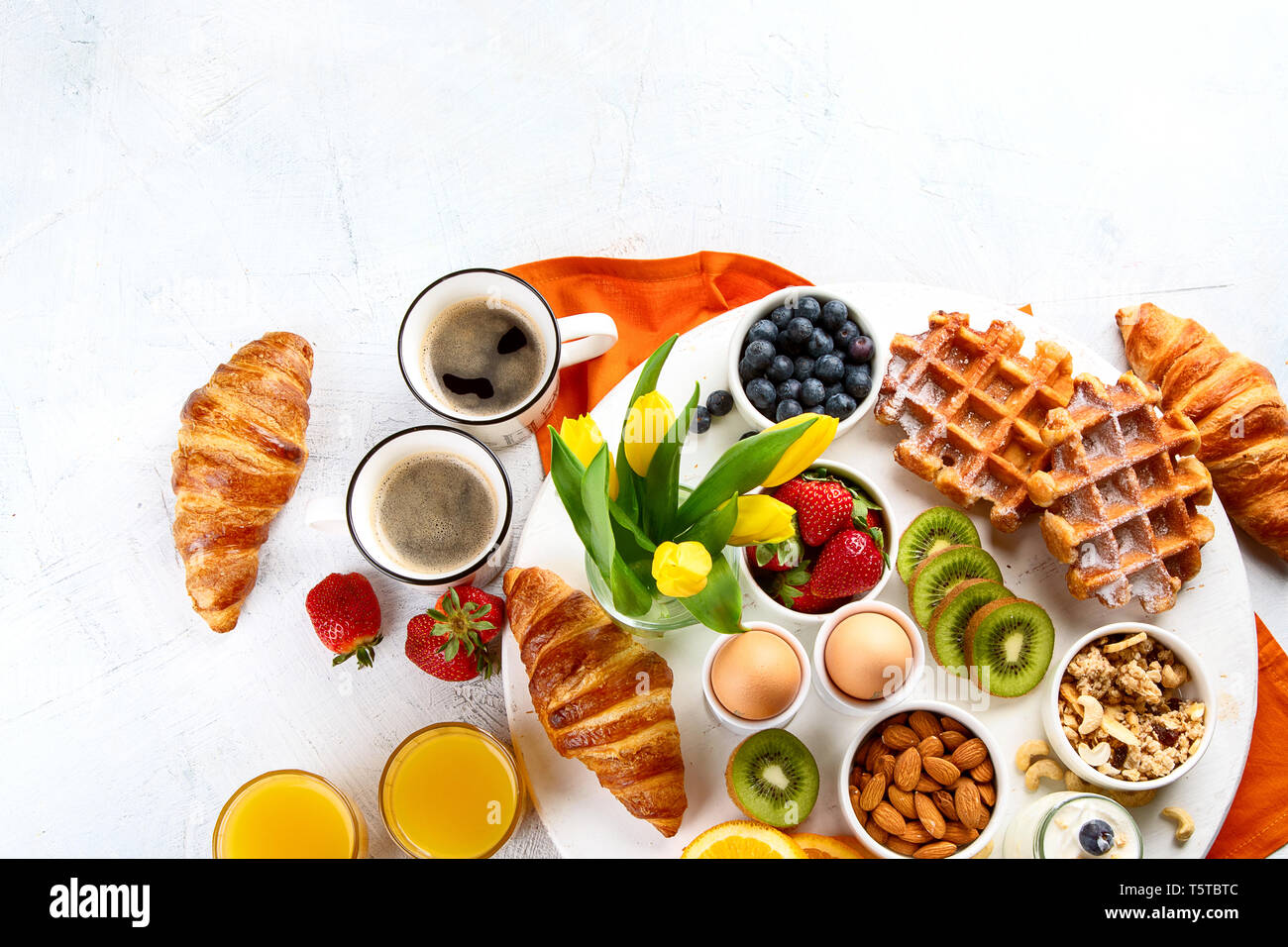 Breakfast table with eggs, berries, yogurt,waffle and croissant. Top ...