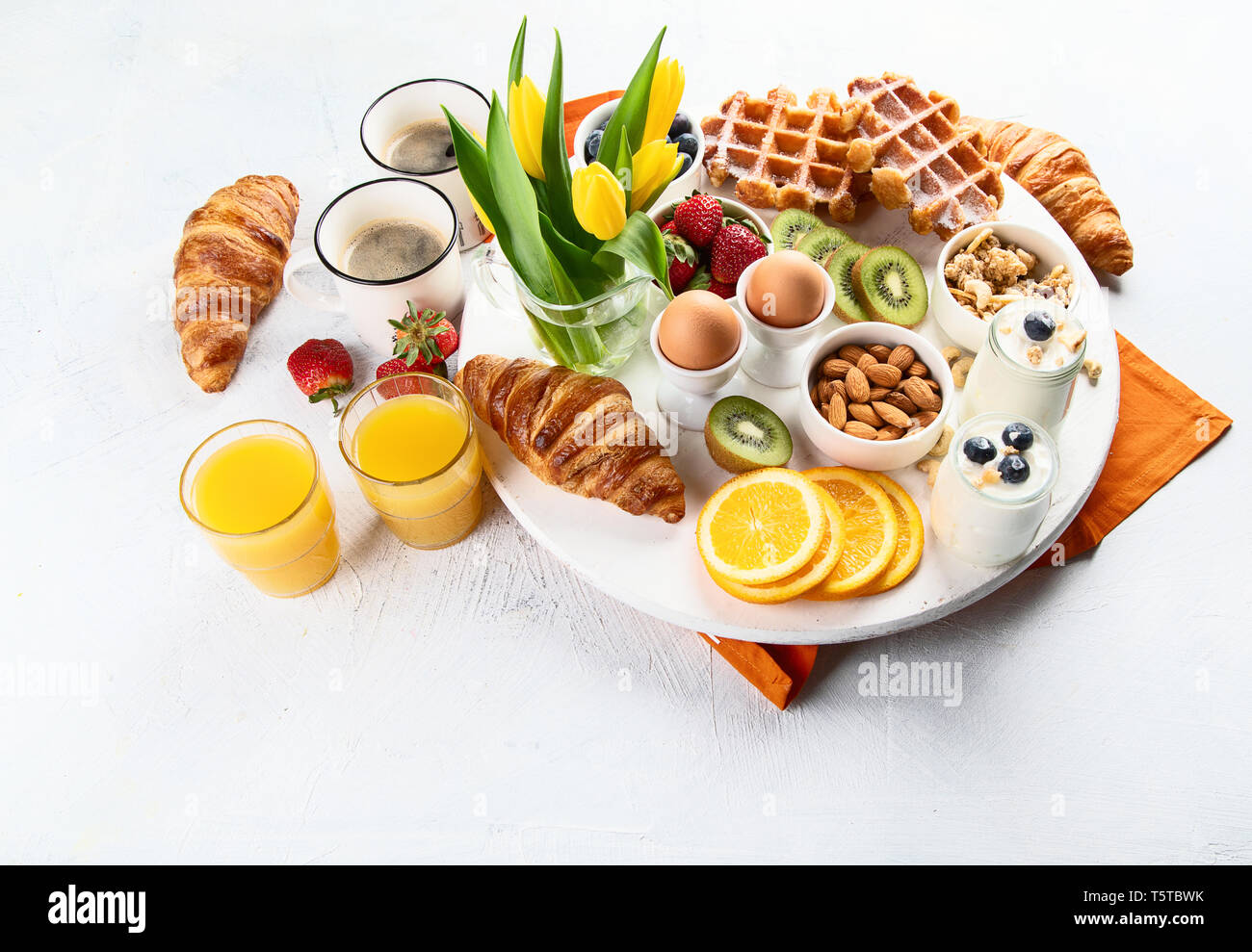Breakfast table with eggs, berries, yogurt,waffle and croissant. Image ...