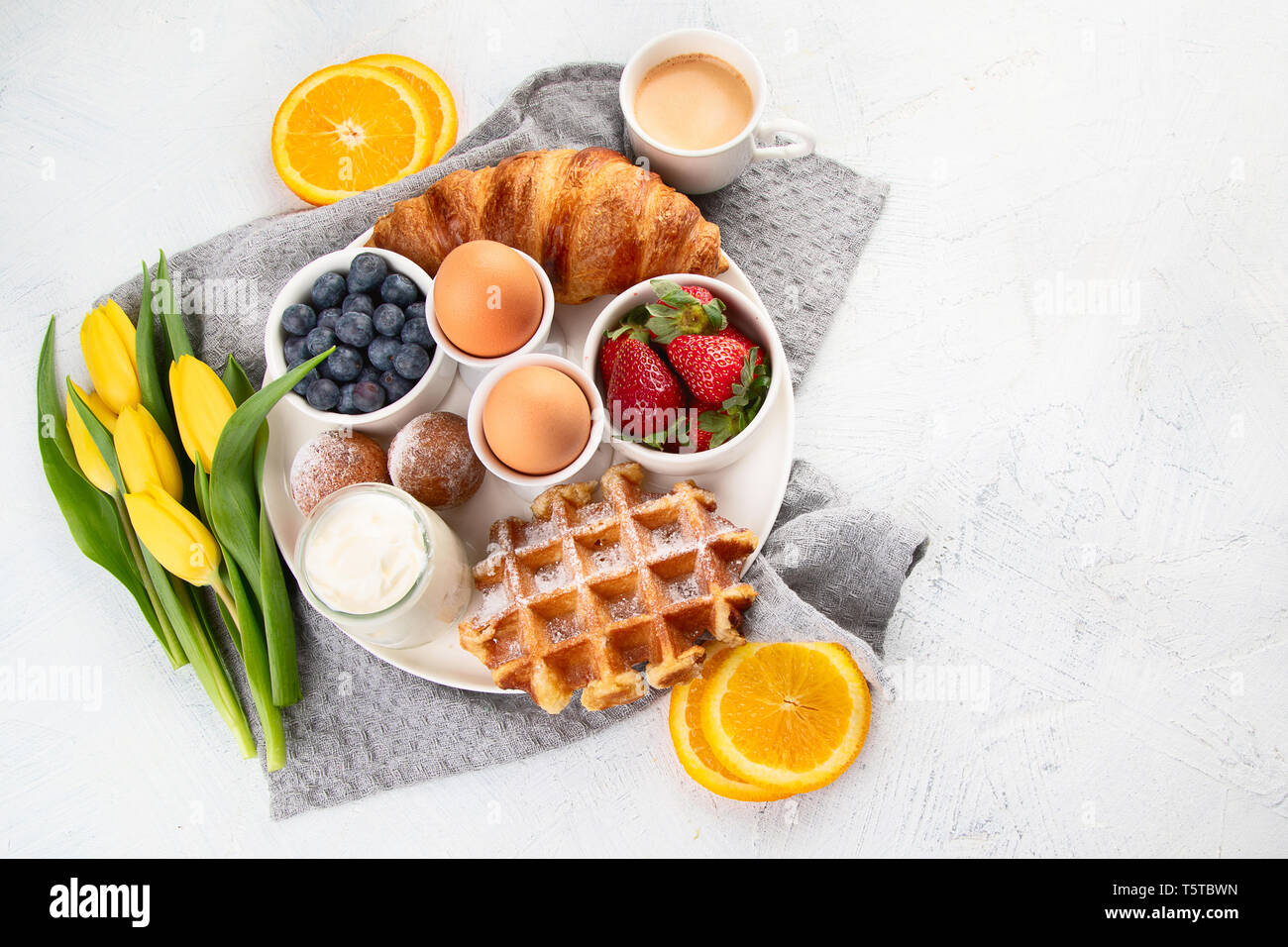 Breakfast table with eggs, berries, yogurt,waffle and croissant. Top ...