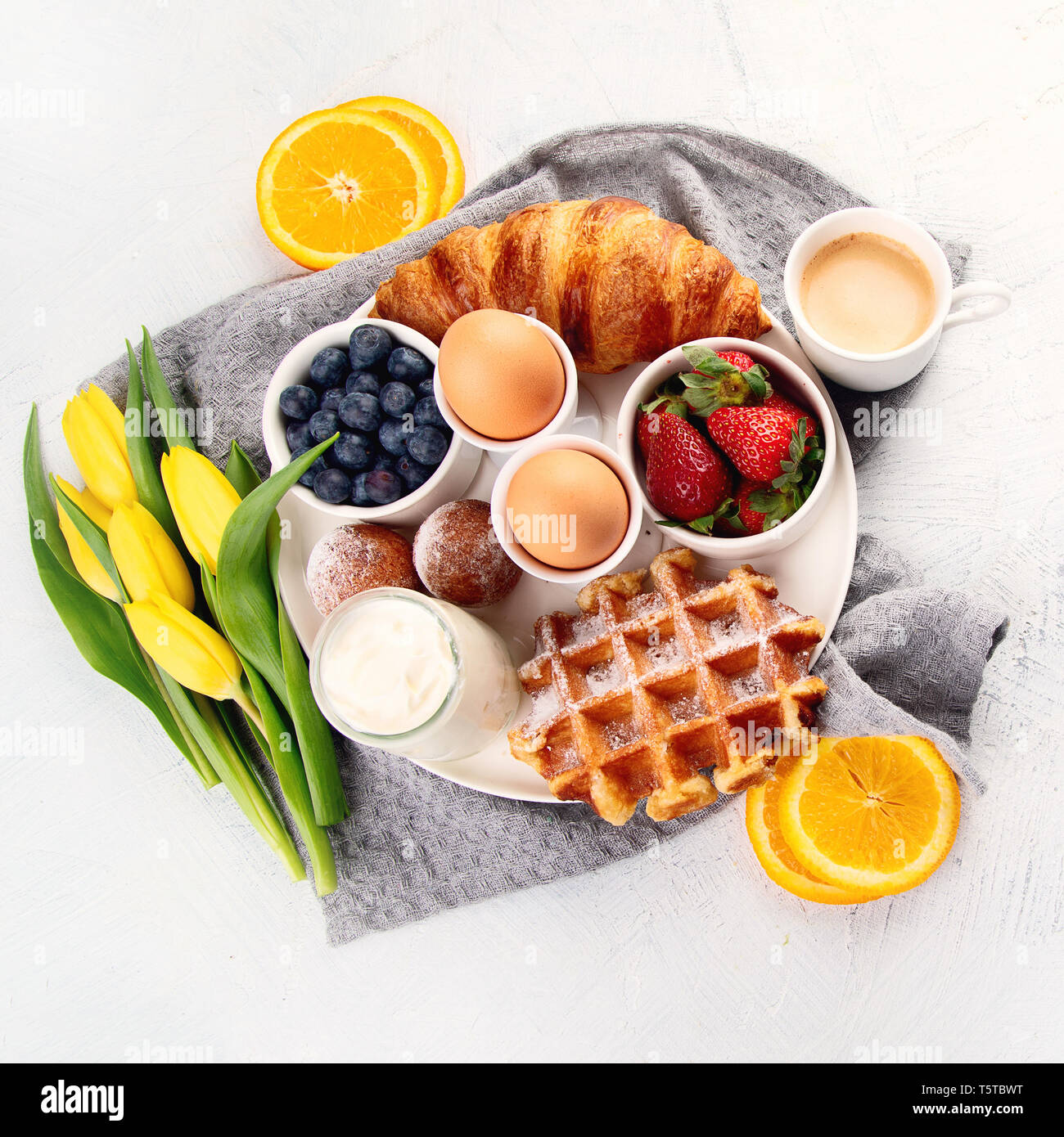 Breakfast table with eggs, berries, yogurt,waffle and croissant. Top ...