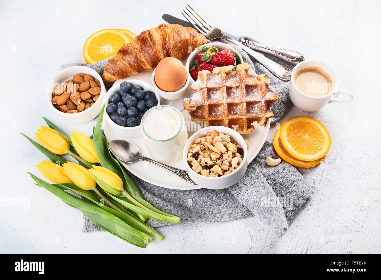 Breakfast table with eggs, berries, yogurt,waffle and croissant. Top ...