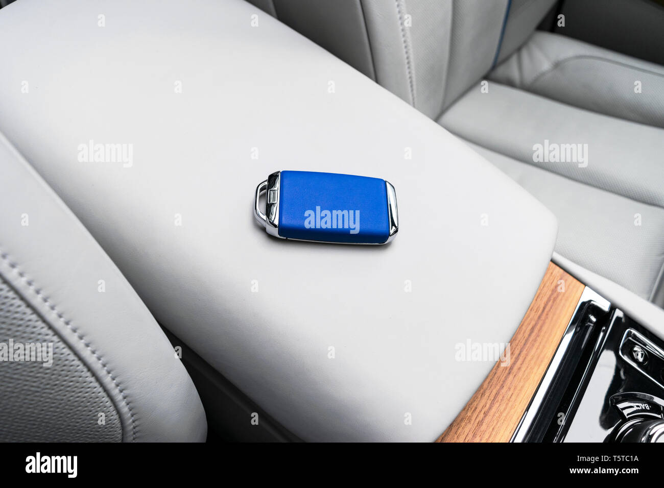 Closeup inside vehicle of wireless blue leather key ignition on natural ...