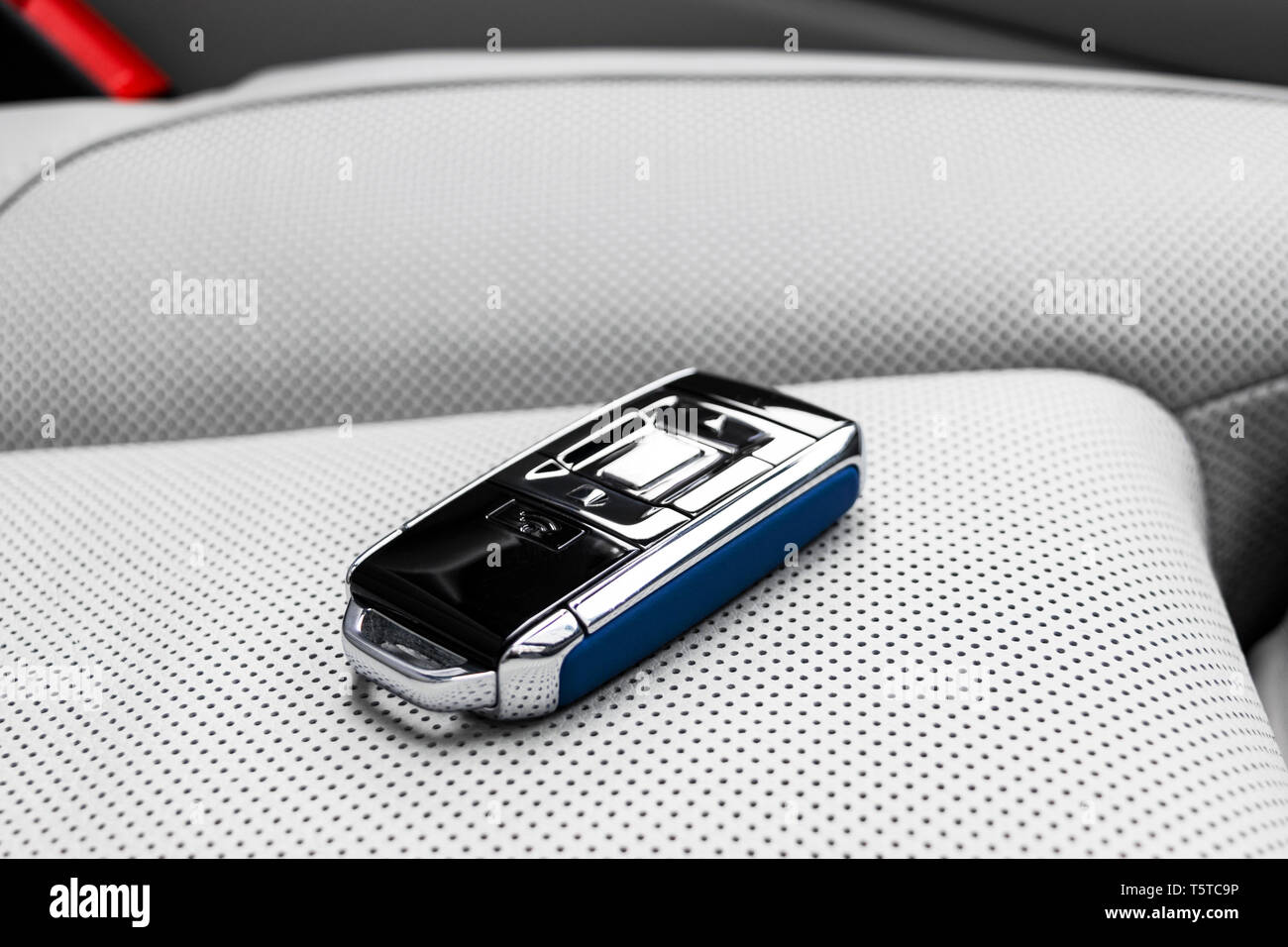 Closeup inside vehicle of wireless blue leather key ignition on white ...