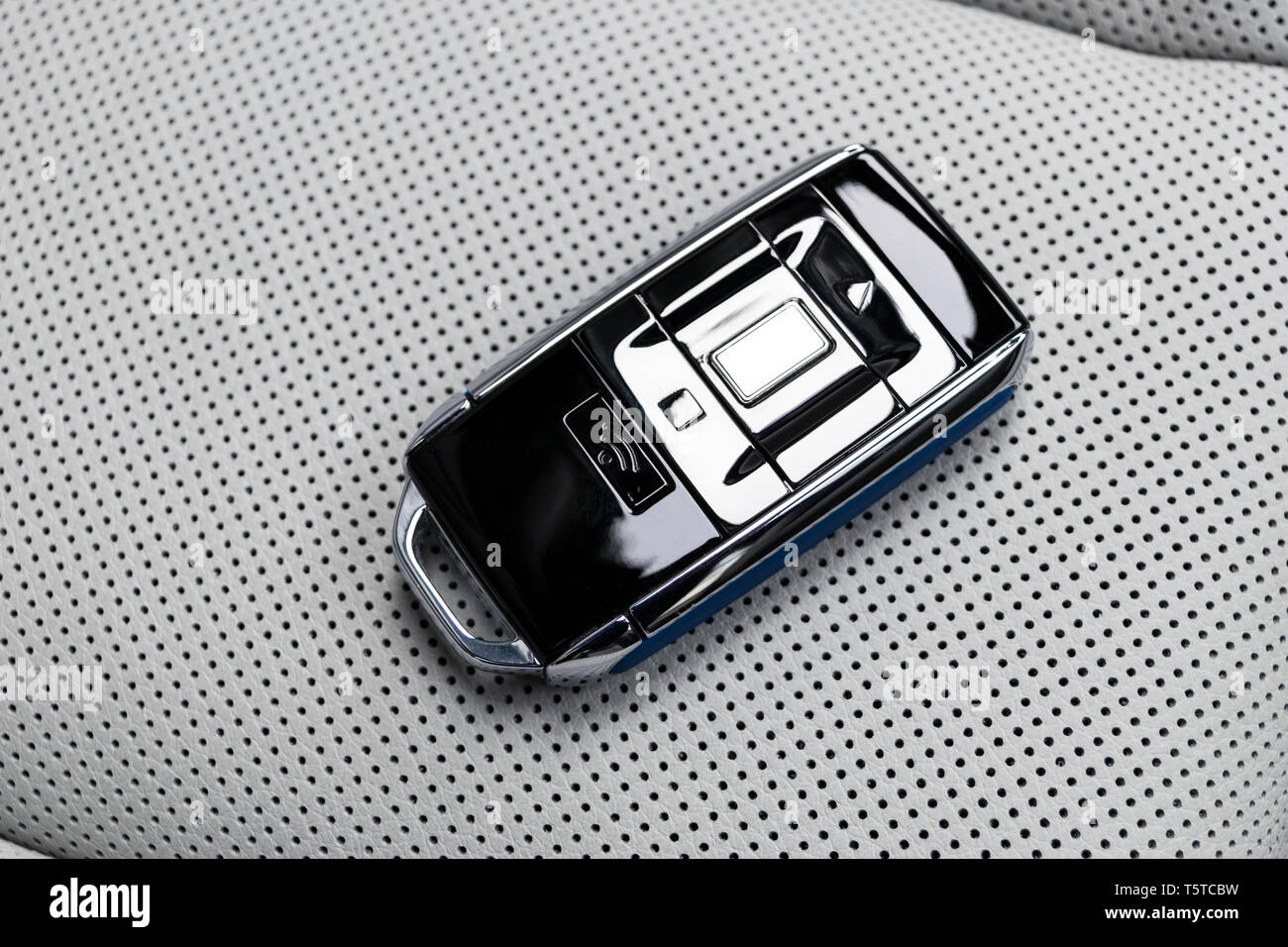 Closeup inside vehicle of wireless blue leather key ignition on white ...