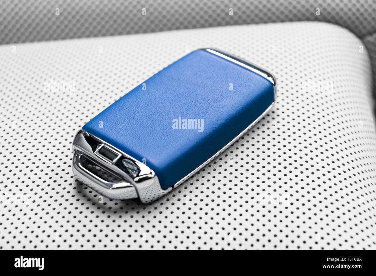 Closeup inside vehicle of wireless blue leather key ignition on white ...