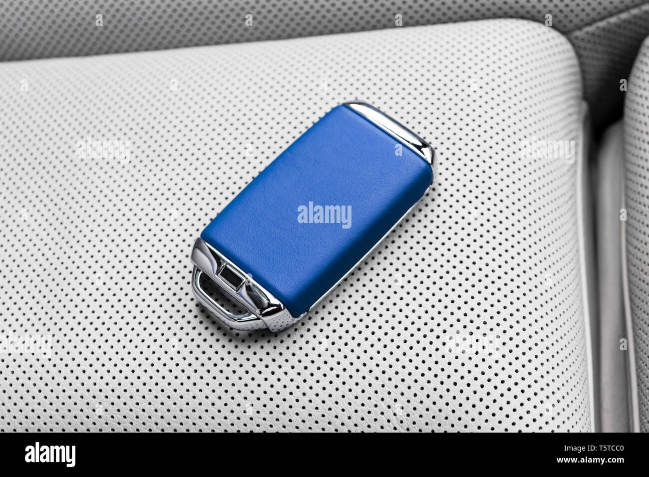 Closeup inside vehicle of wireless blue leather key ignition on white ...