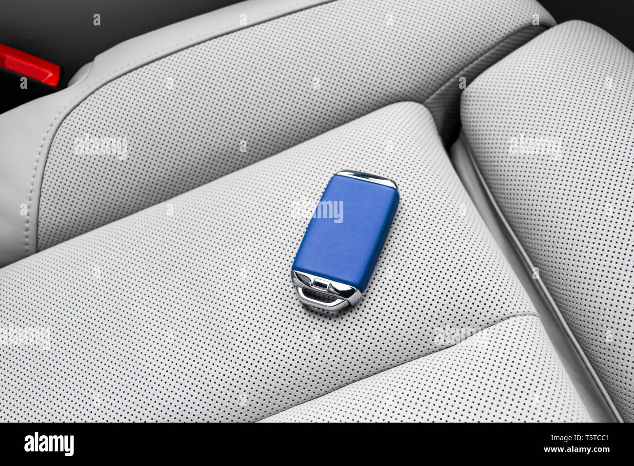 Closeup inside vehicle of wireless blue leather key ignition on white ...