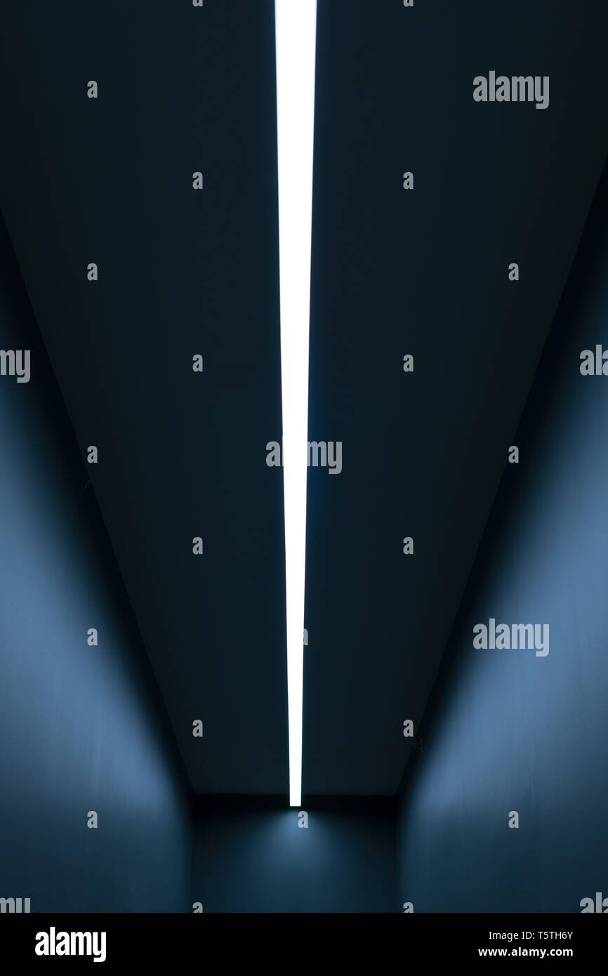 Vertical light in a long blue room Stock Photo - Alamy