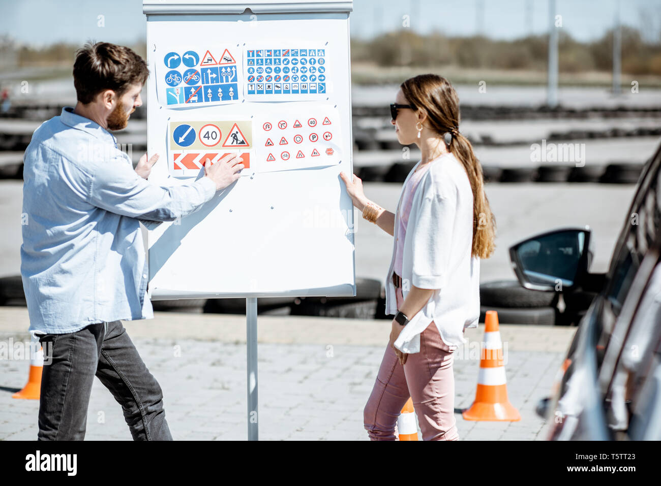 Male instructor showing traffic signs to a young female student ...