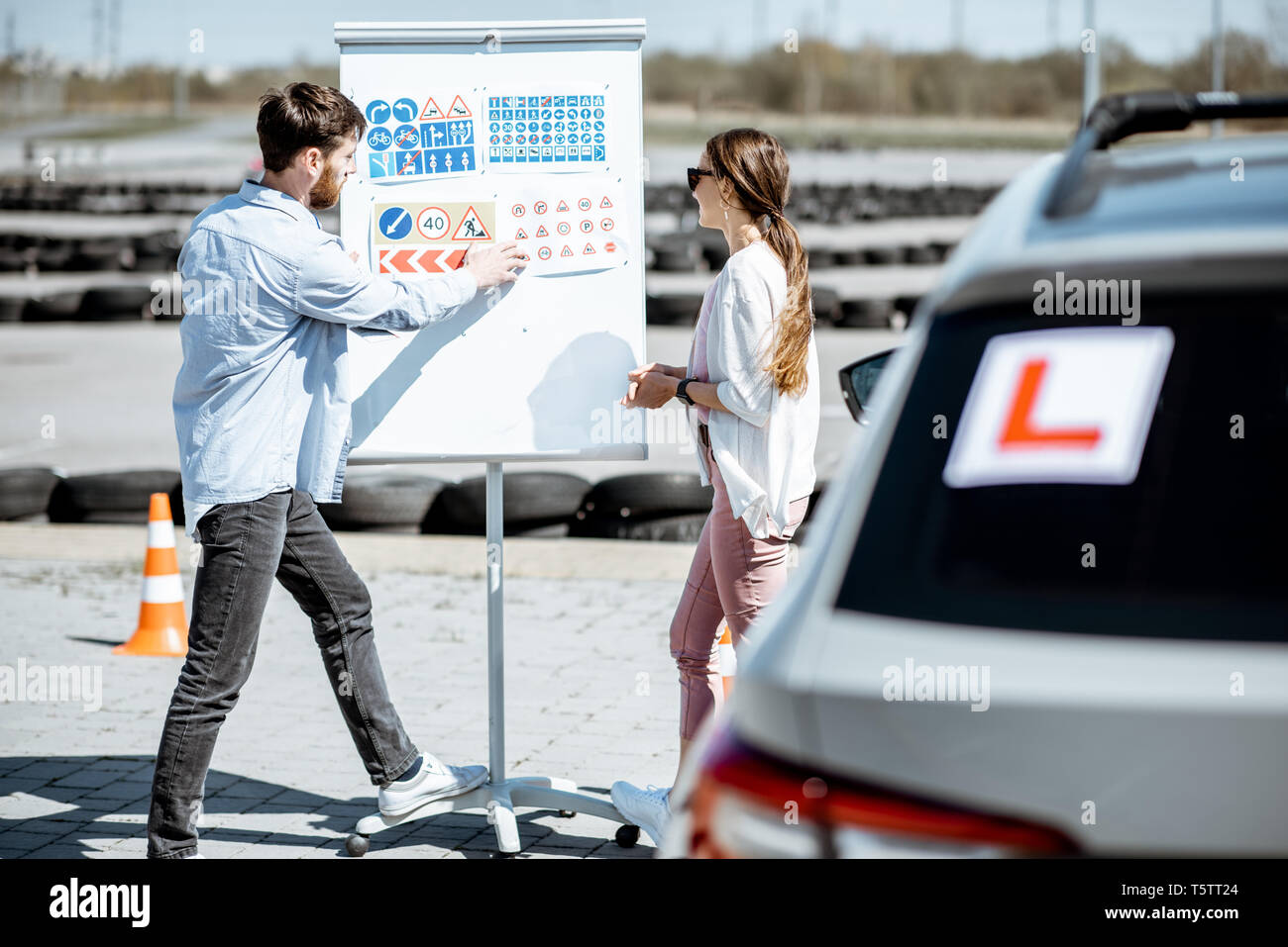 Male instructor showing traffic signs to a young female student ...
