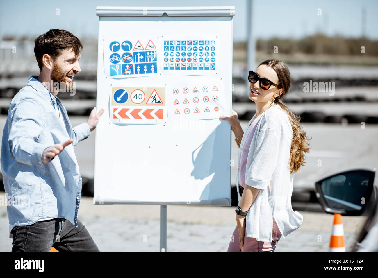 Male instructor showing traffic signs to a young female student ...